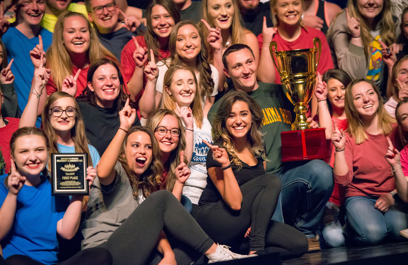 A group of UW fraternity and sorority members proudly hold up trophies after an FSL event